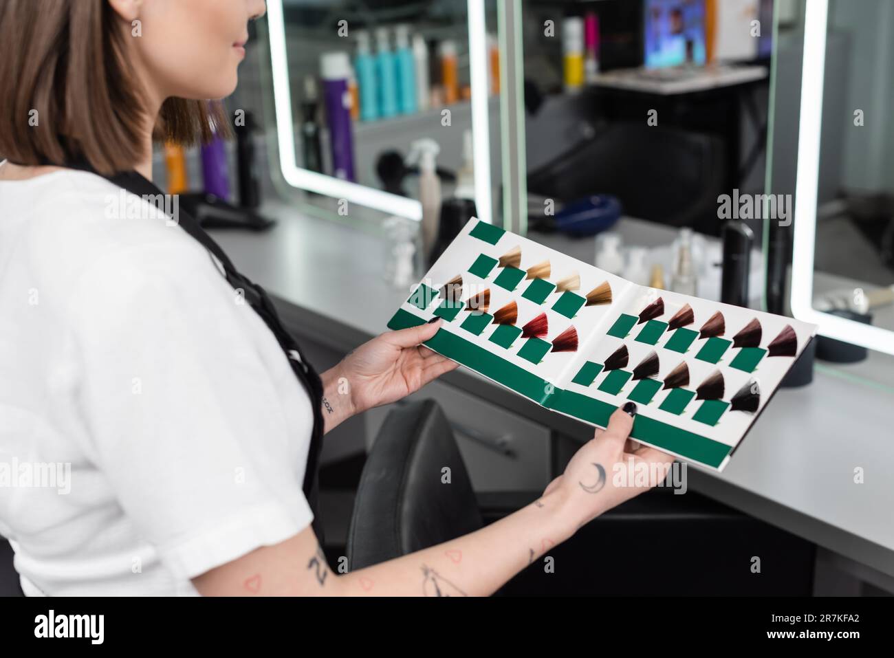 hair professional, tattooed beauty worker in apron holding hair color ...