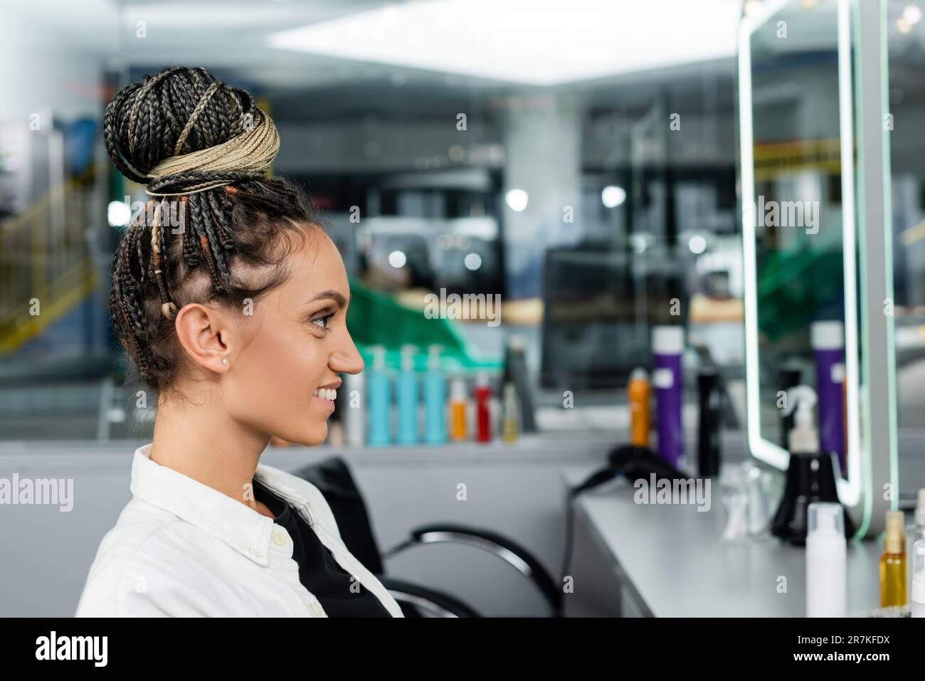 side view, happy client in beauty salon, cheerful woman with hair bun ...