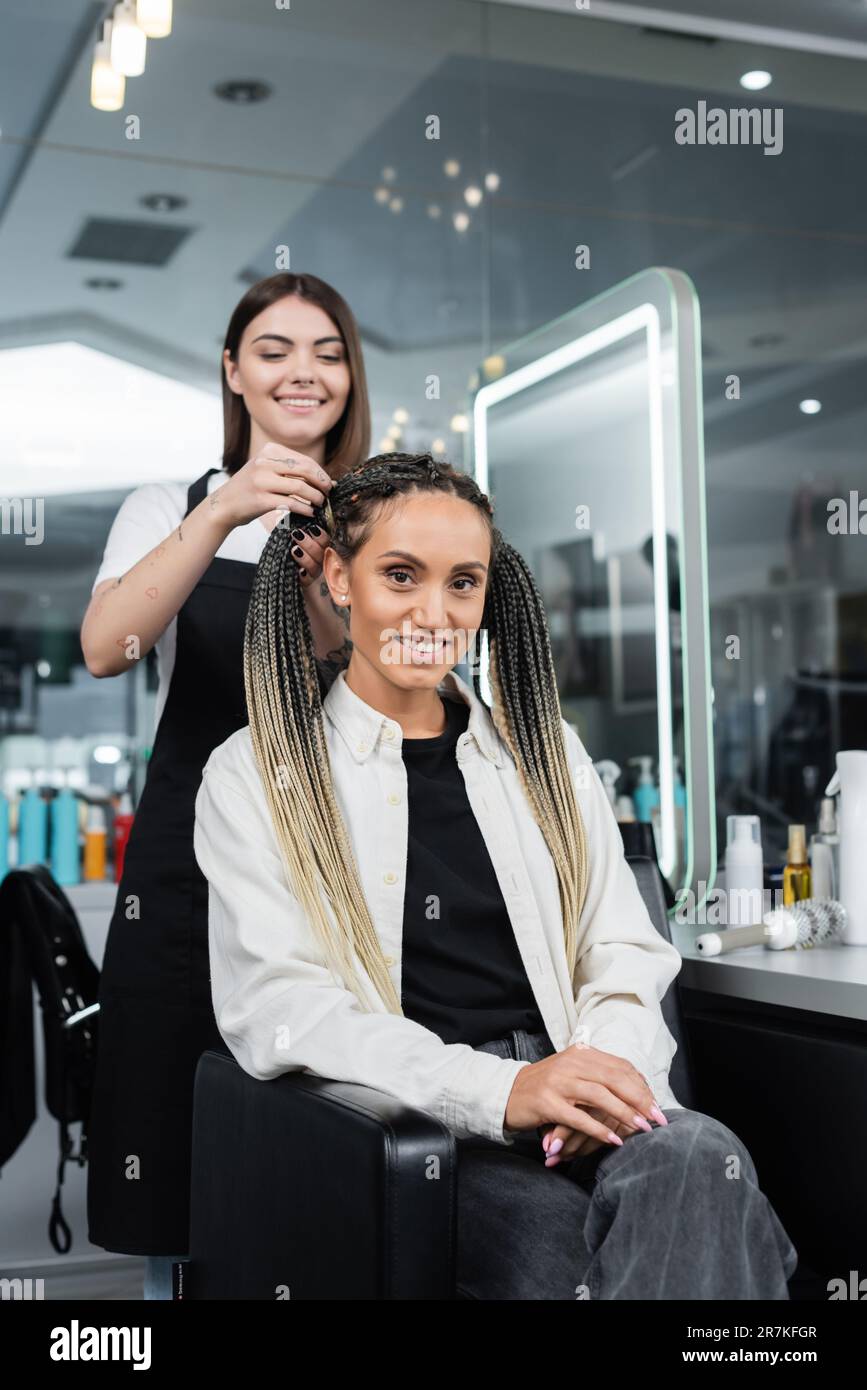 hairdresser and client, beauty salon, cheerful woman with braids and ...