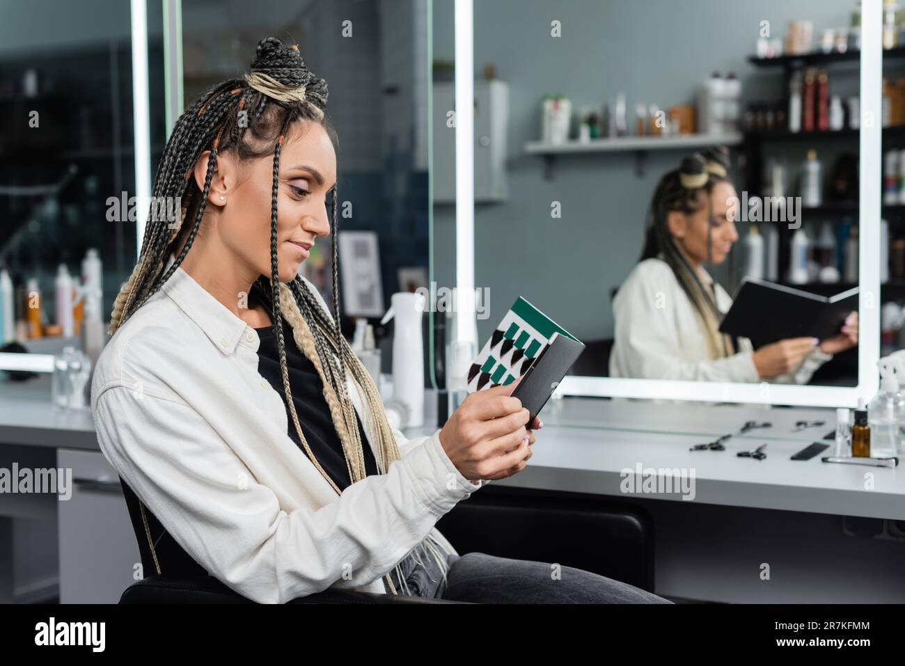 happy woman in beauty salon, joyful client with braids looking at hair ...