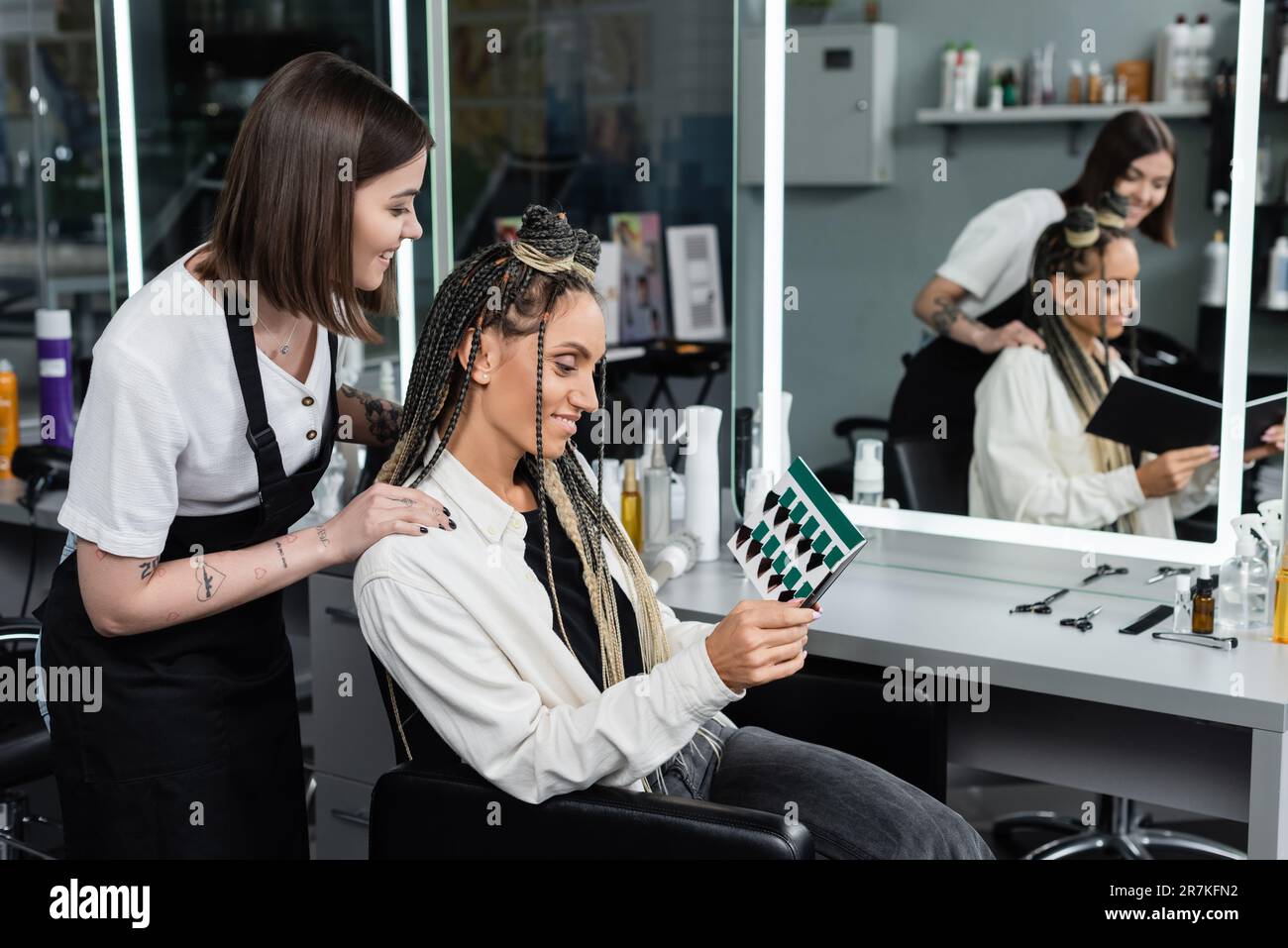 happy woman in beauty salon, joyful client with braids looking at hair ...