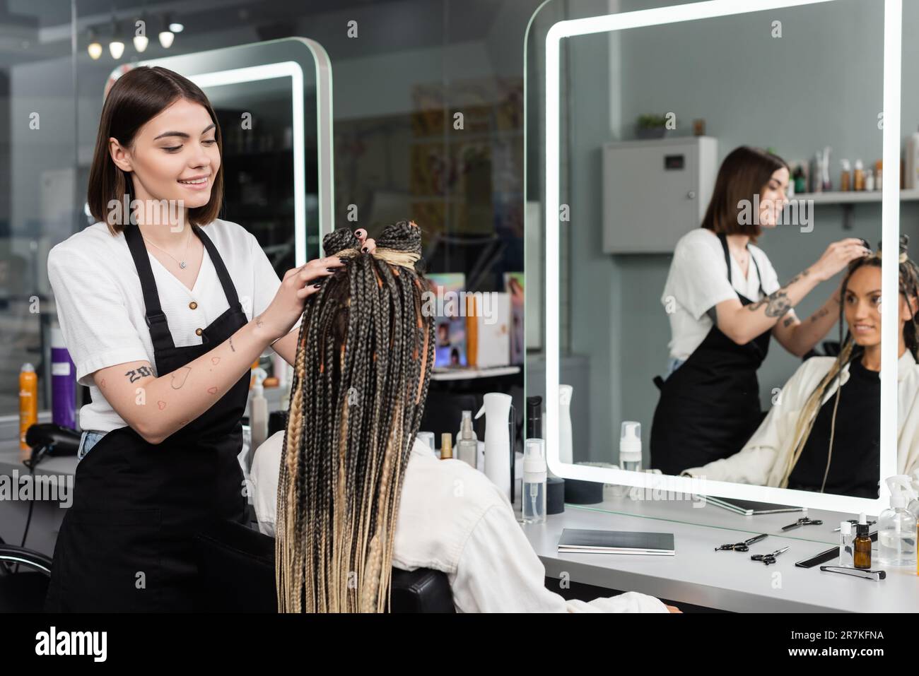 beauty, hair industry, tattooed hairdresser styling hair of woman with ...