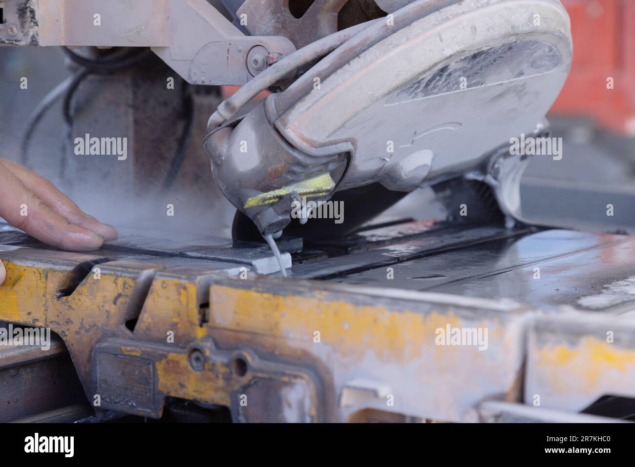 An employee cuts ceramic tile on wet saw with diamond blade Stock Photo ...