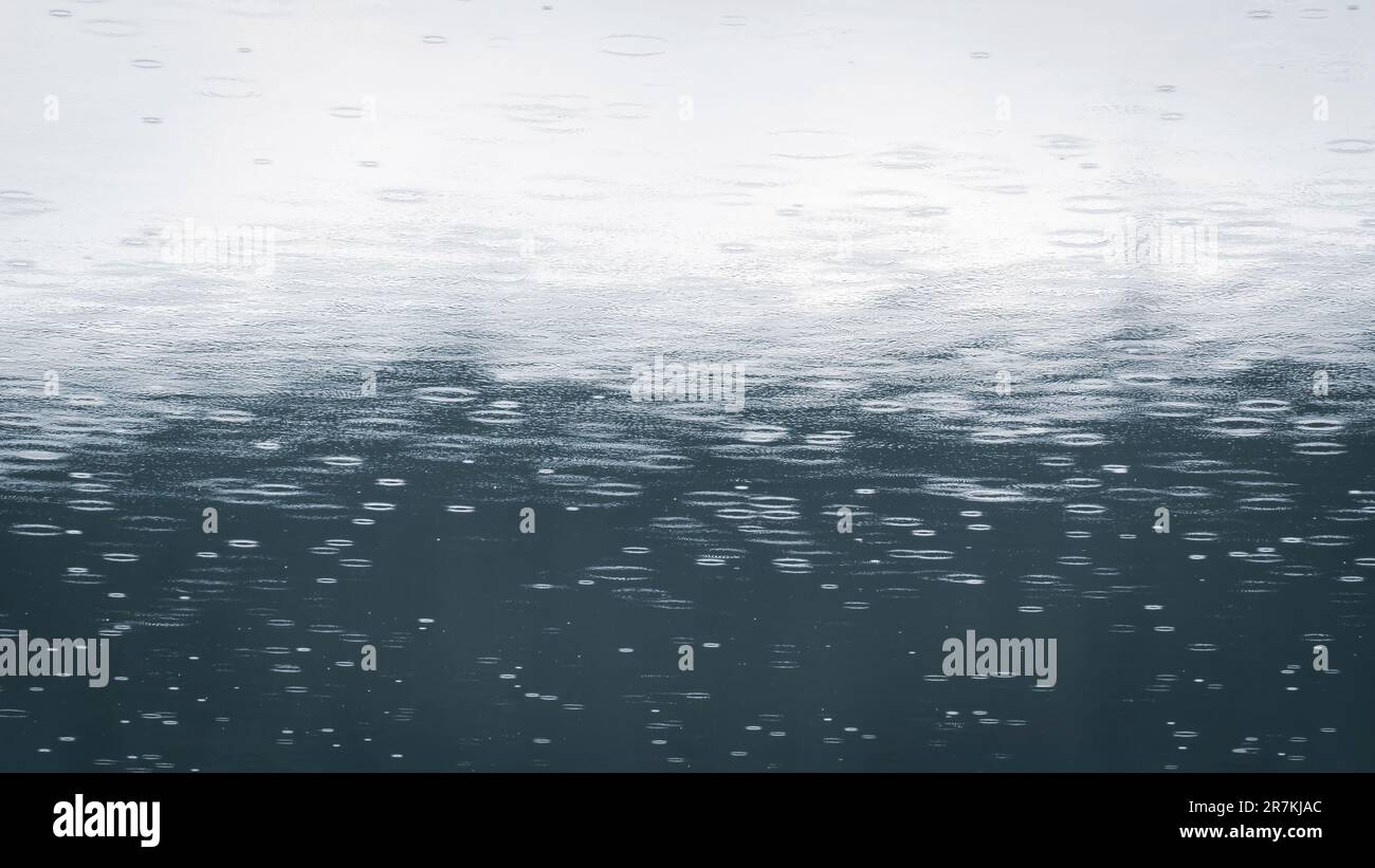 Raindrops on water surface. Raindrops falling on teal colored water ...