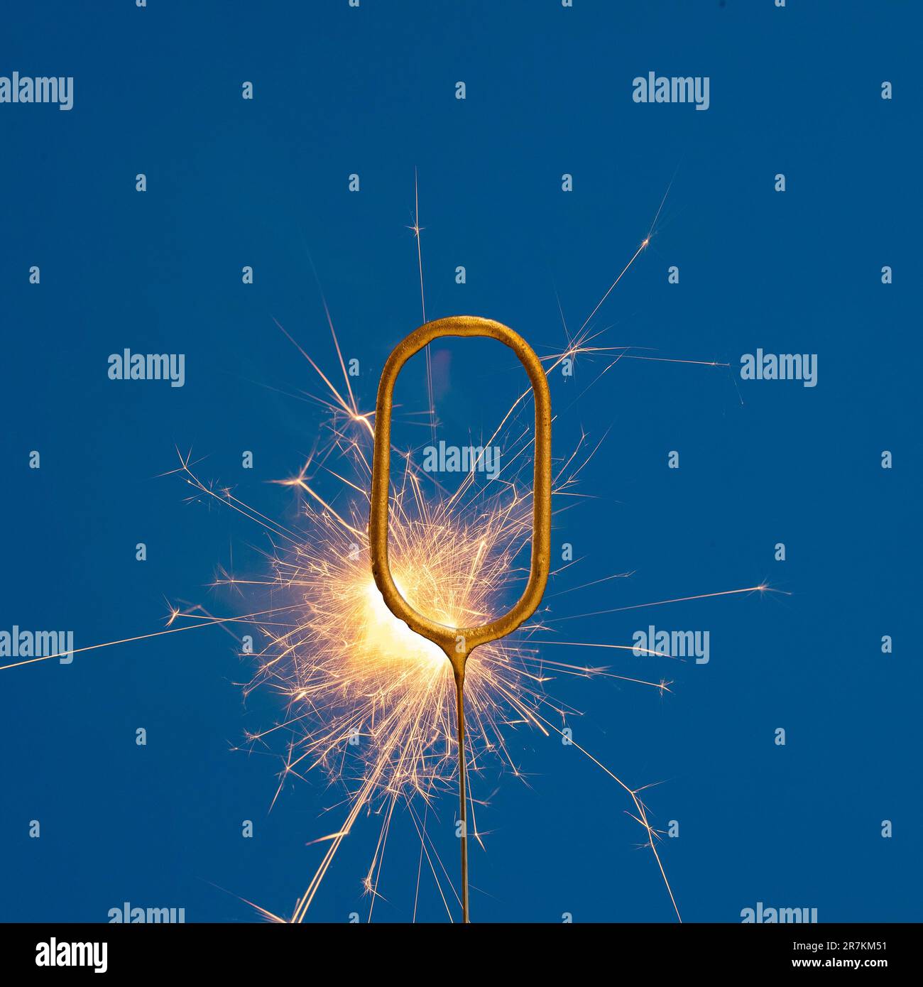 Burning sparkler number 0 - Birthday on blue background Stock Photo - Alamy