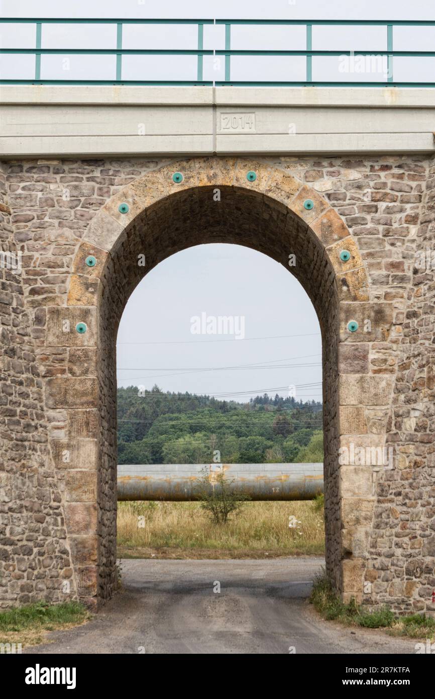 Arch bridge overpassing a small road Stock Photo - Alamy