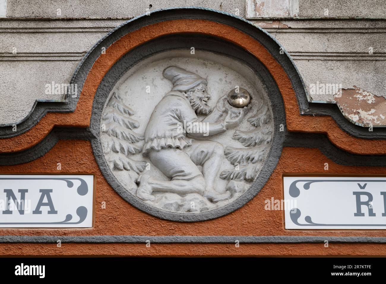 A sign decorated with a relief depicting a dwarf holding a precious ...