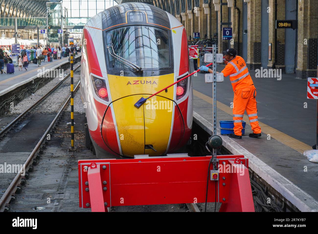 London UK. 16 June 2023 . A staff member at King's Cross station cleans ...