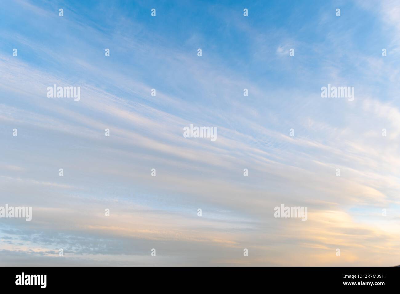 sunset sky with pink clouds, diagonally stripe, grey above. Whispy pink clouds and blue sky ...