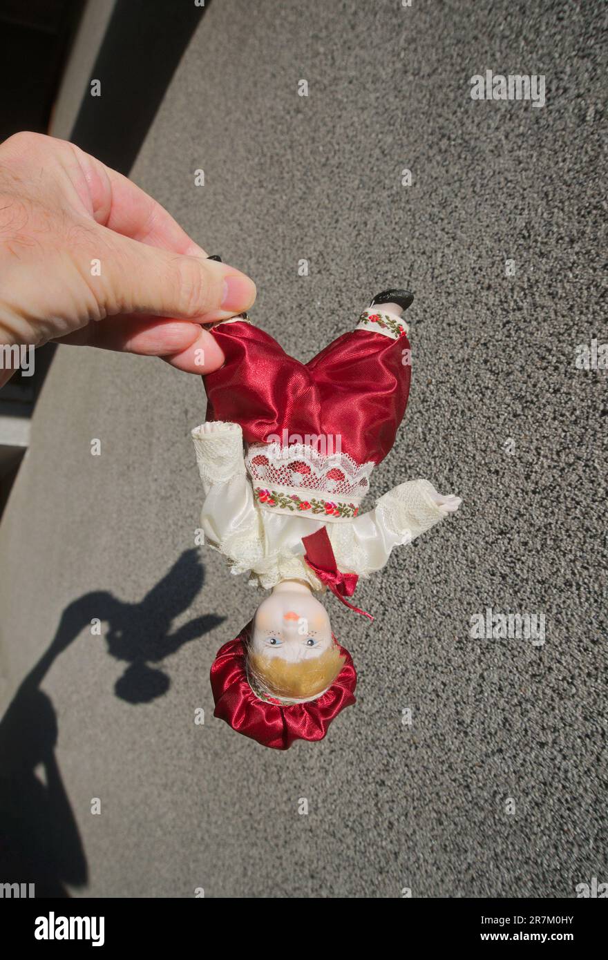 hand holding doll upside down Stock Photo - Alamy
