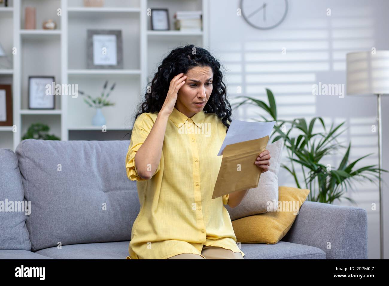 Upset and sad woman at home receiving bad news notification letter ...