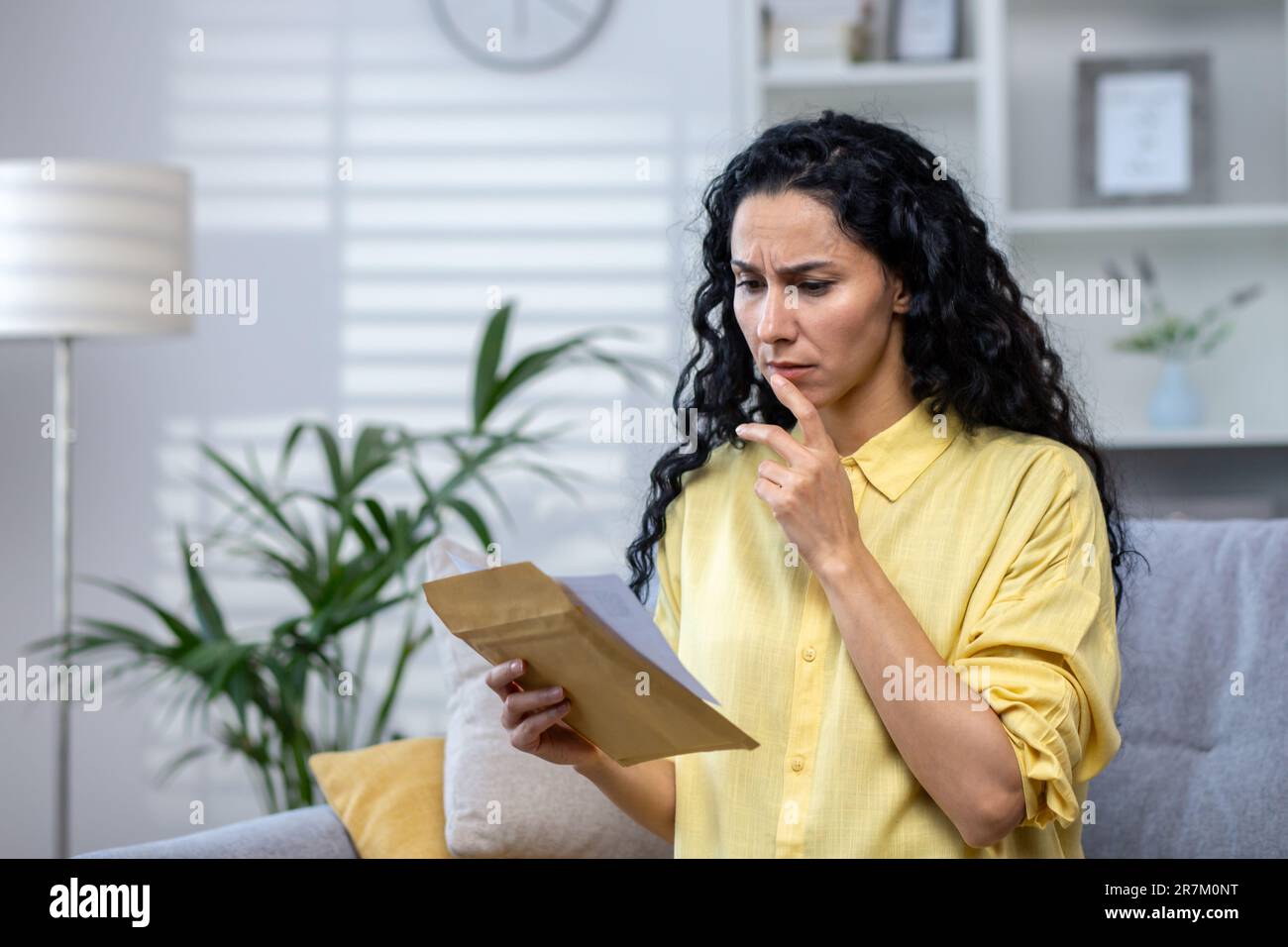 Upset and sad woman at home receiving bad news notification letter ...