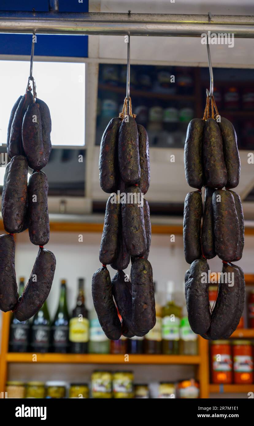 Spanish pork sausages black chorizo hanging on butchers shop on farmers ...
