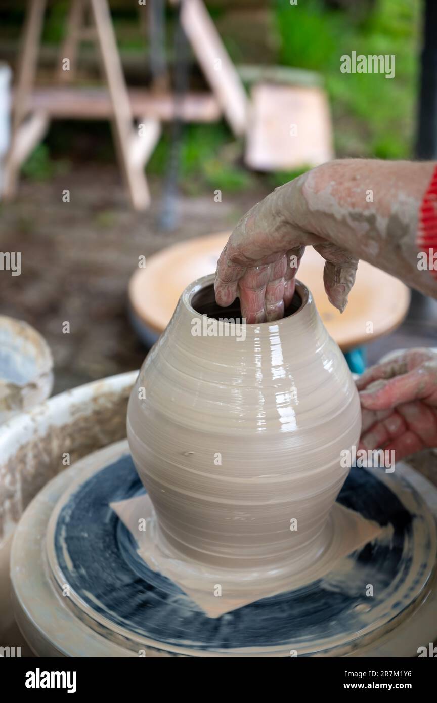 Making of mud pot on potters wheel during workshop outdoor in ...