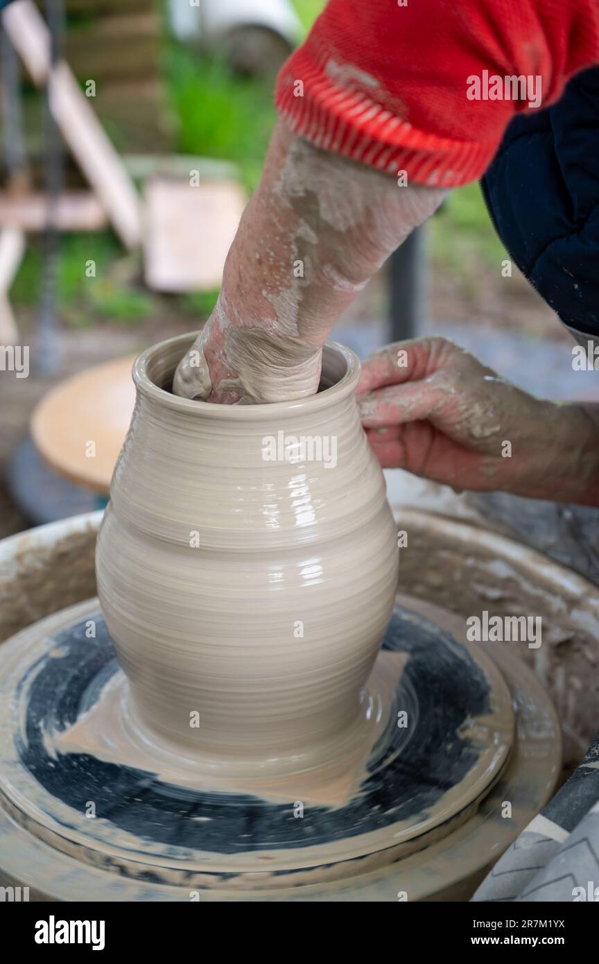Making of mud pot on potters wheel during workshop outdoor in ...