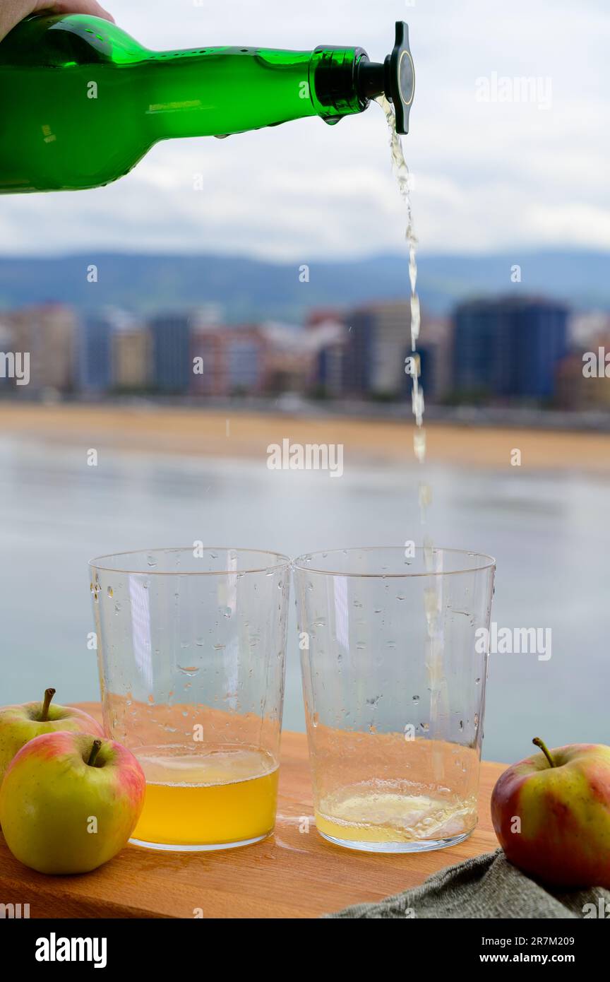 Pouring of natural Asturian cider made from fermented apples in wooden ...
