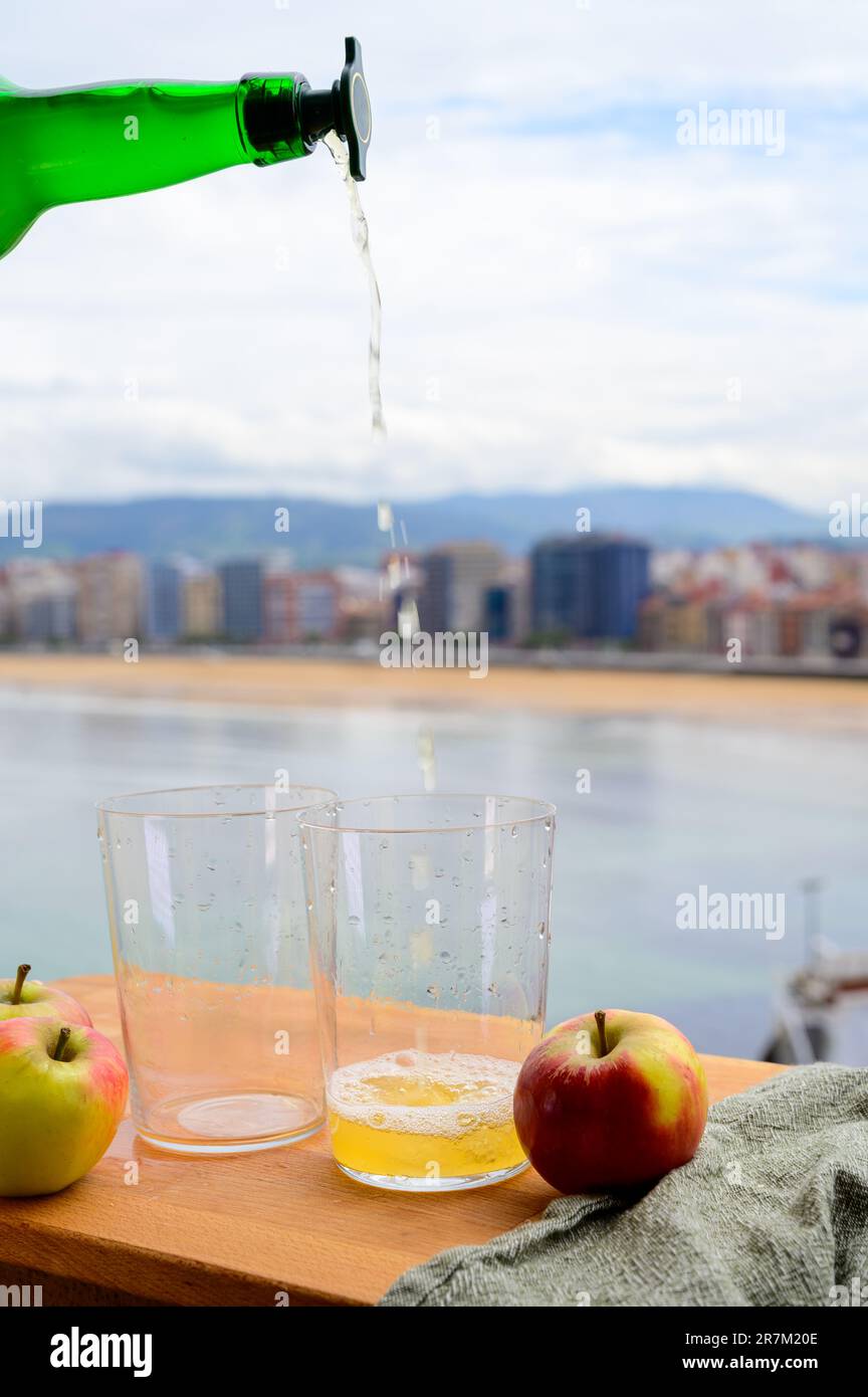 Pouring of natural Asturian cider made from fermented apples in wooden ...