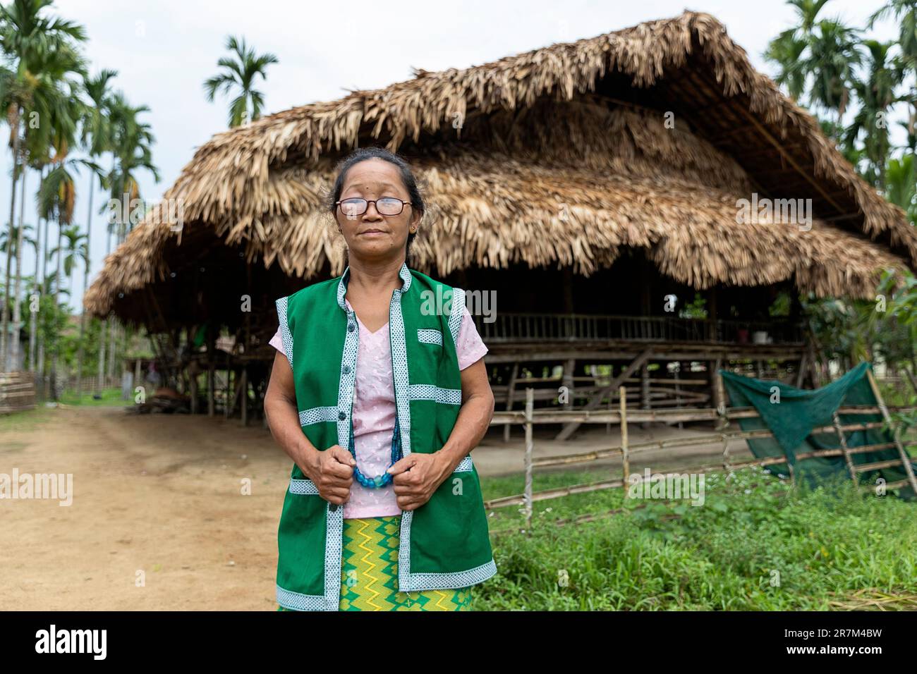 Woman from galo tribe in her traditional clothes posing infront of her traditional house made ...