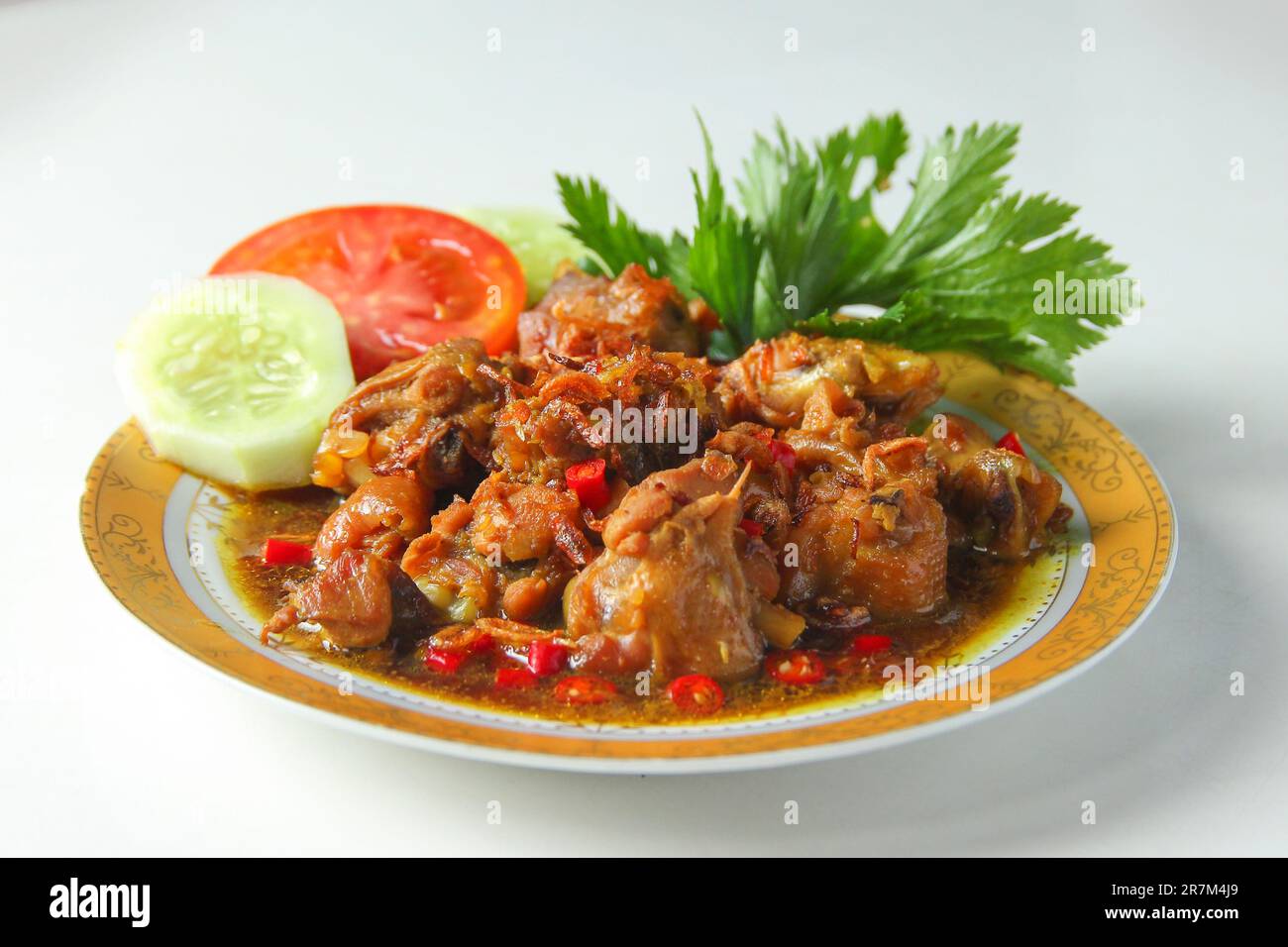 Indonesian food culinary on antique plate.chicken rica-rica with tomato ...