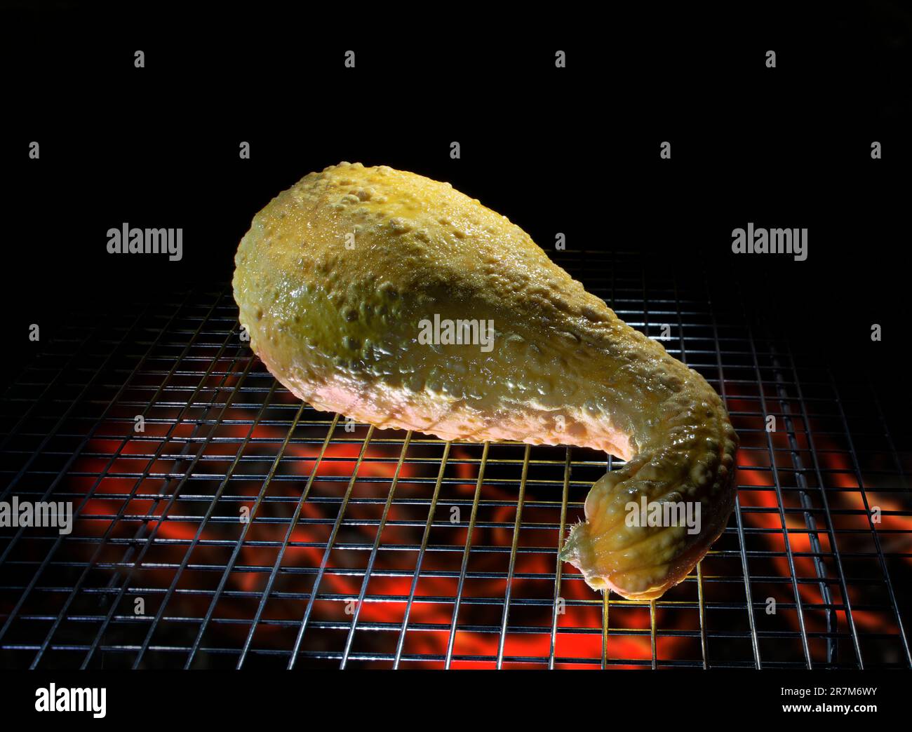 Yellow squash on a grate with flames coming up underneath Stock Photo ...