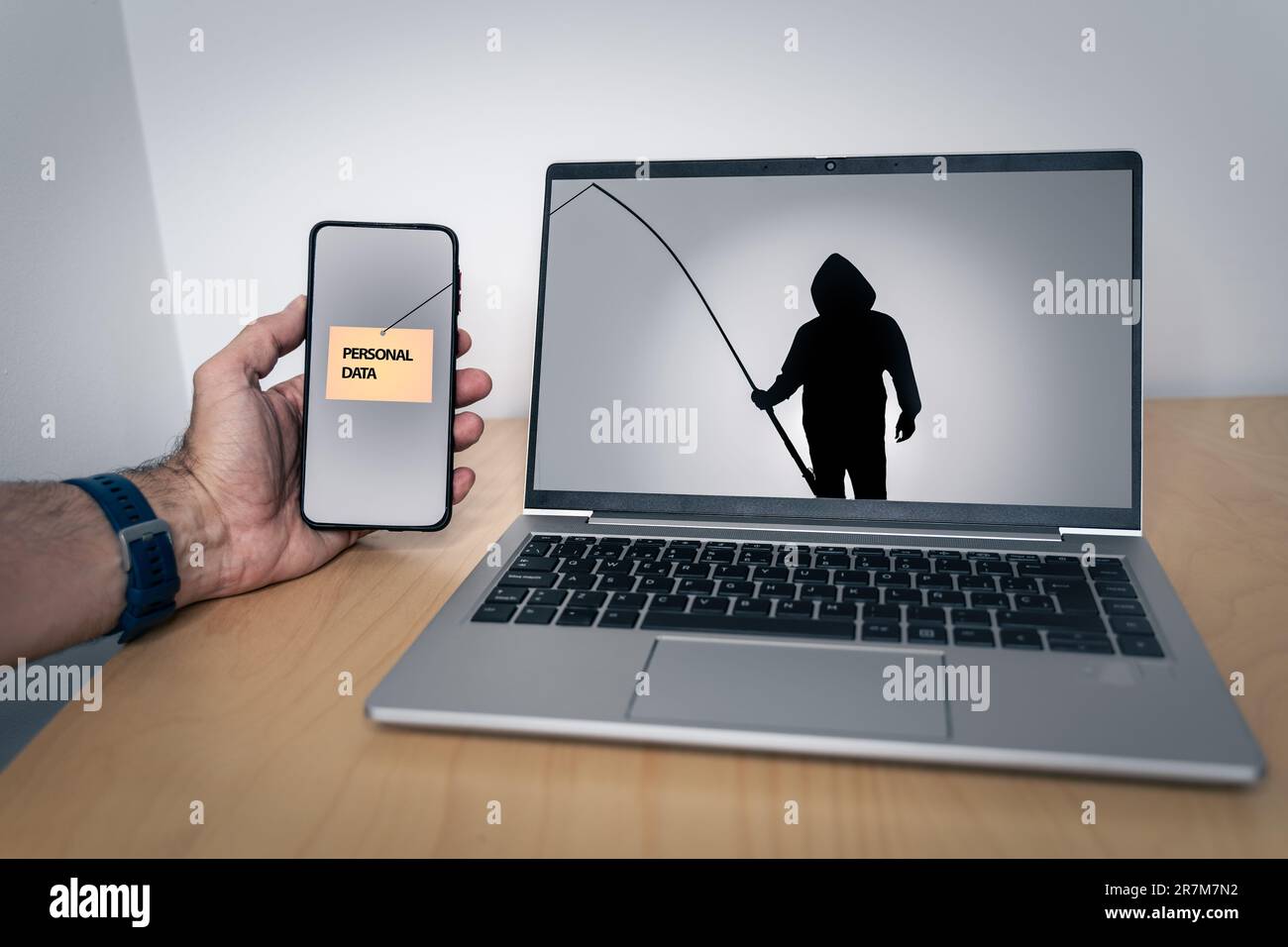 Silhouette of a hacker with a fishing rod on a laptop screen stealing ...