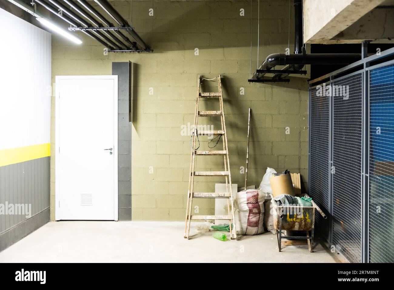 A maintenance area in the basement is pictured, featuring a ladder and ...