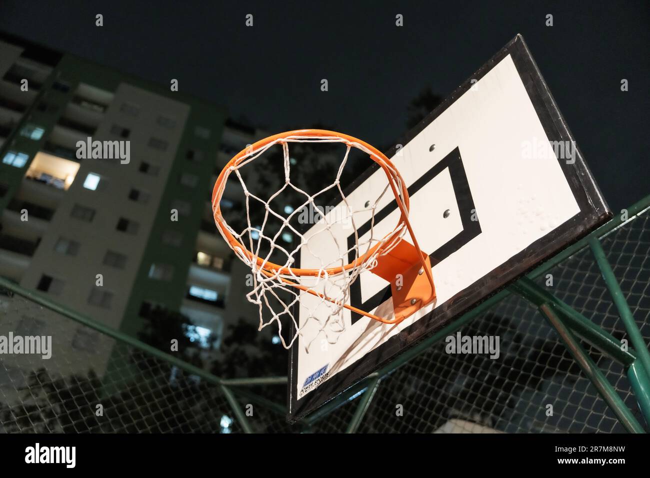 A close-up of a basketball hoop with an orange-colored rim and wire ...