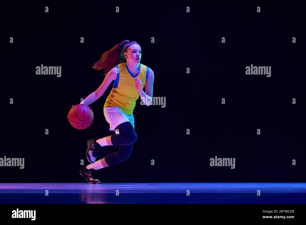 Young concentrated girl, basketball player in motion, running with ball ...