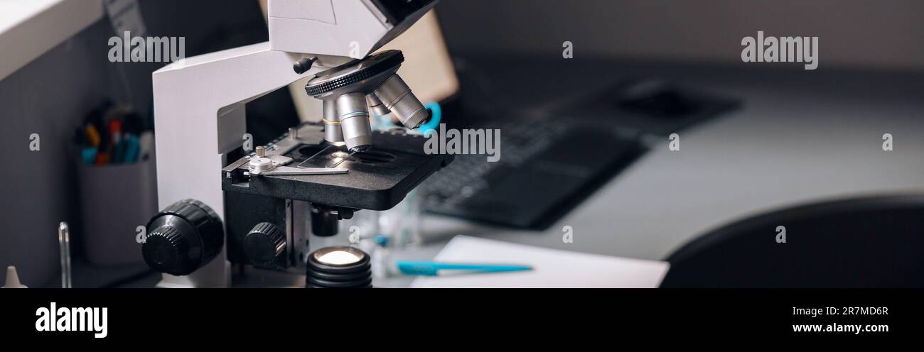 Microscope, rack with test tubes and vials on table in laboratory Stock ...
