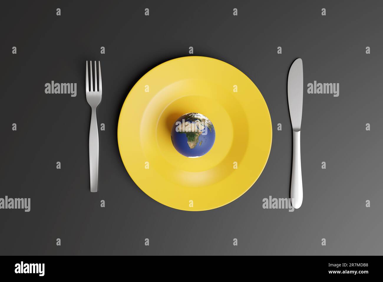 The earth on a yellow dining plate with knife and fork on black ...