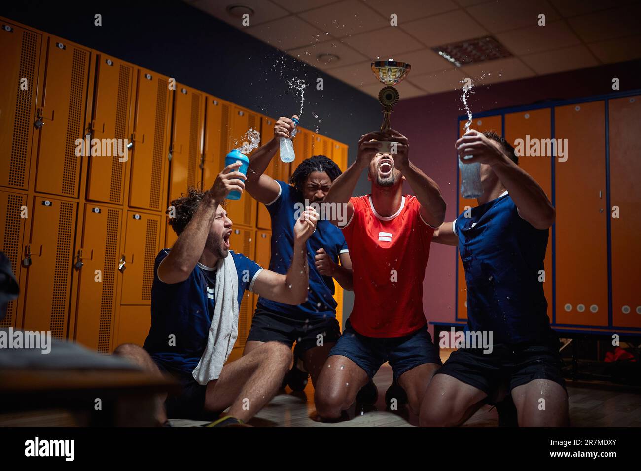 Football team players celebrating success in the dressing room, holding ...
