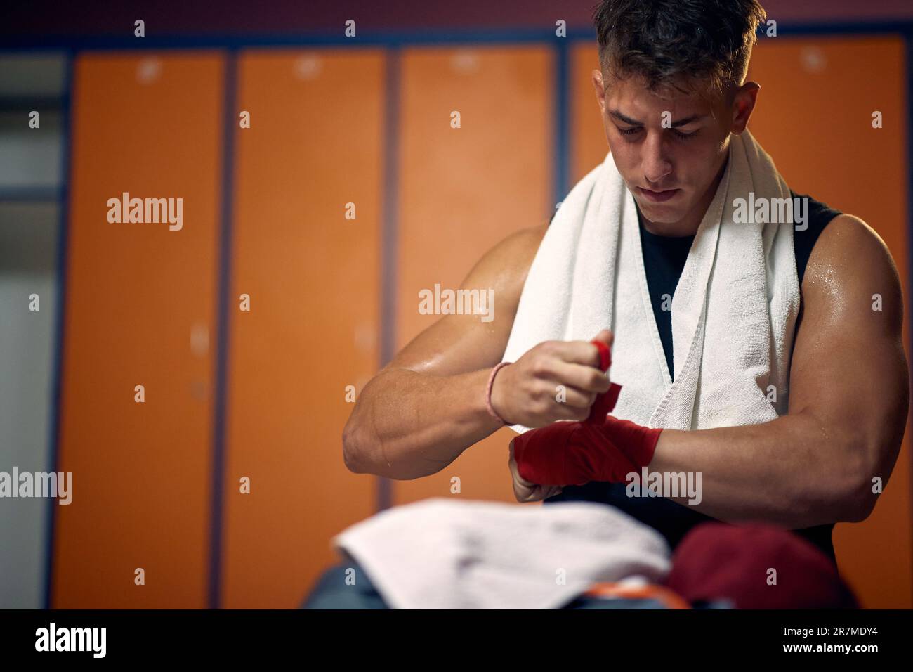 Wide horizontal shot of young sweaty man taking red protective tape of ...