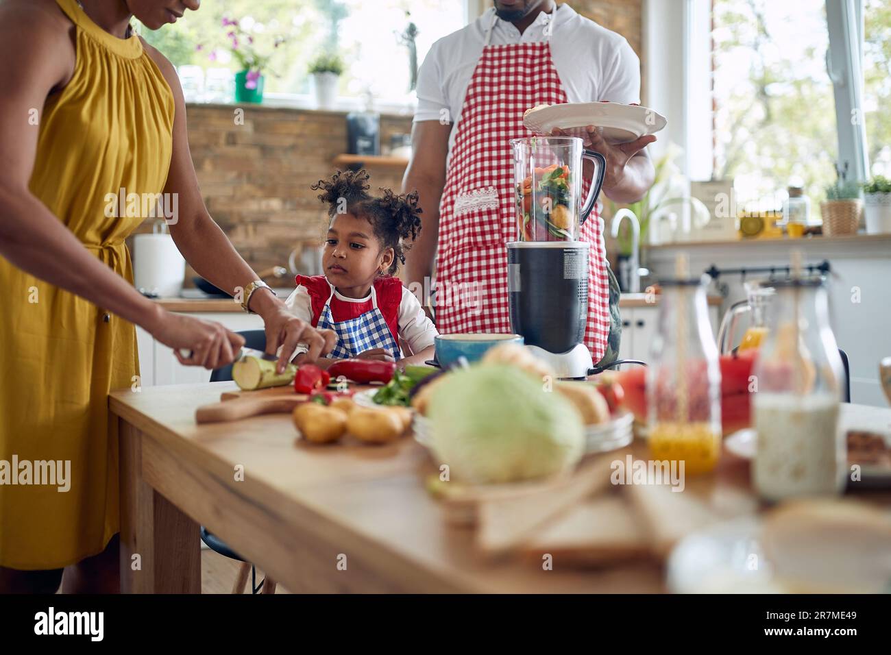 Afro-American family comes together to prepare a meal in their kitchen ...