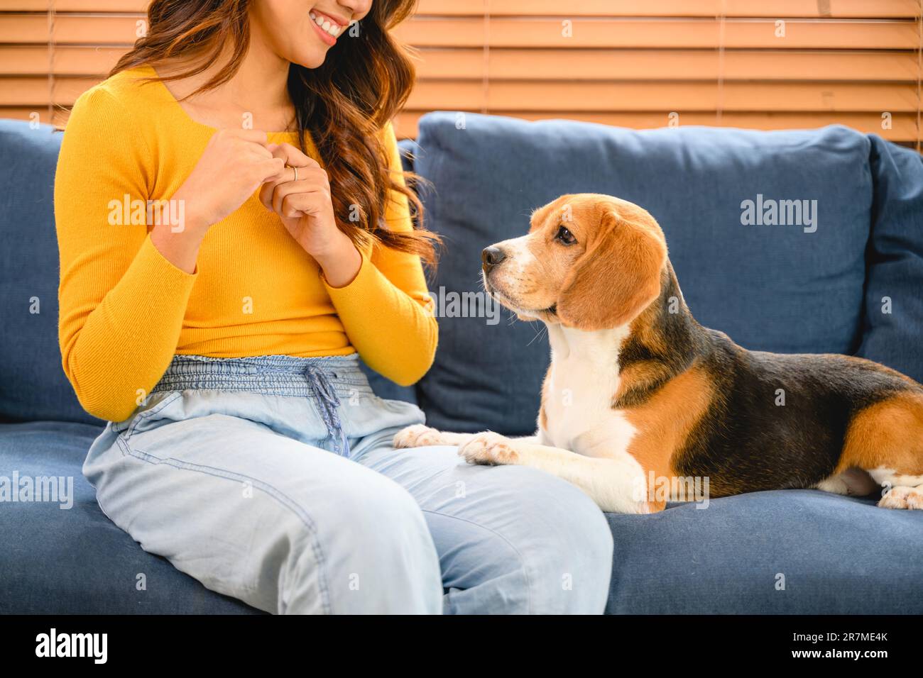 A woman is shown in a friendly interaction with her dog, a playful ...