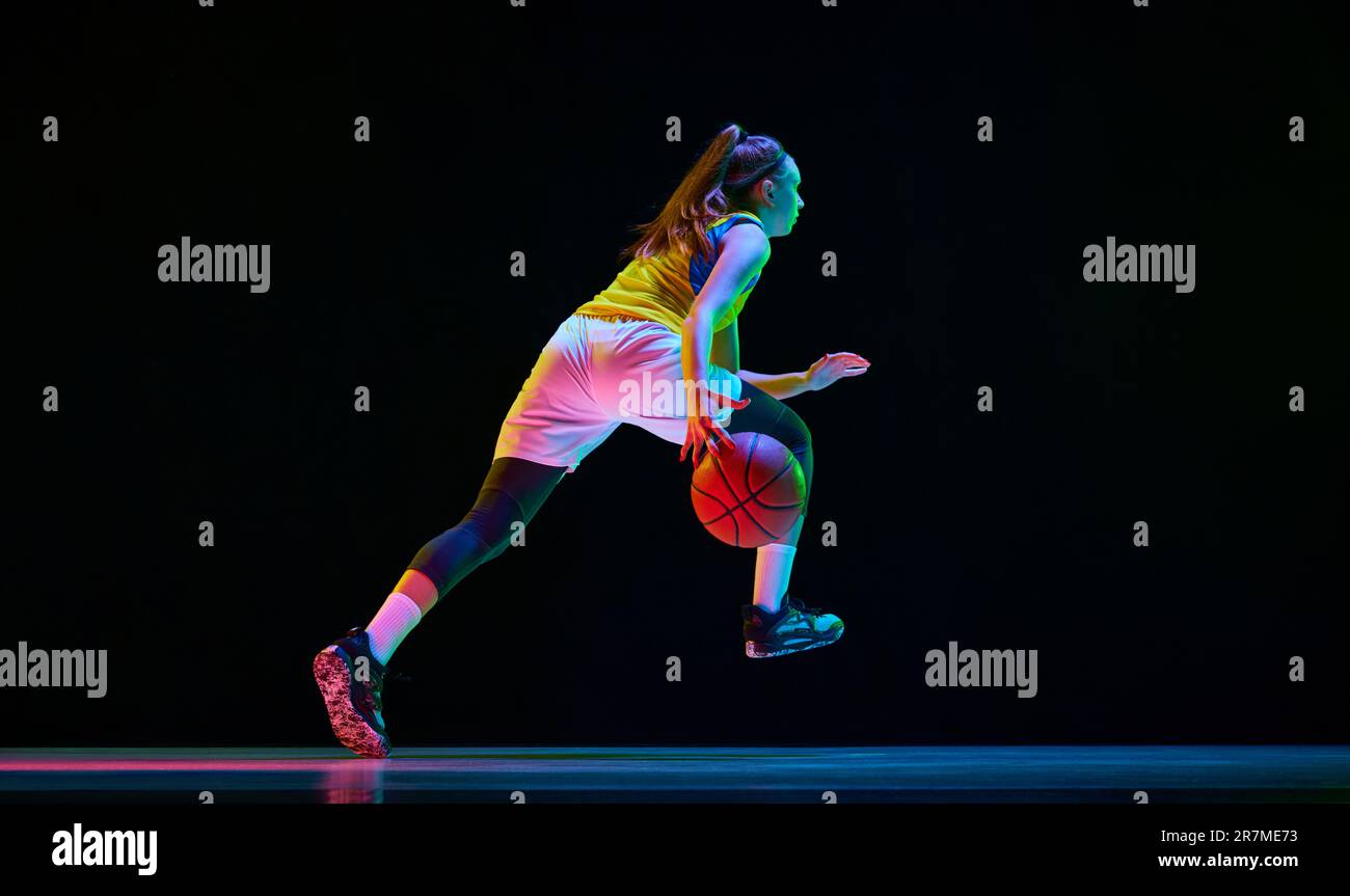 Side bottom view image of young girl, basketball player in motion ...