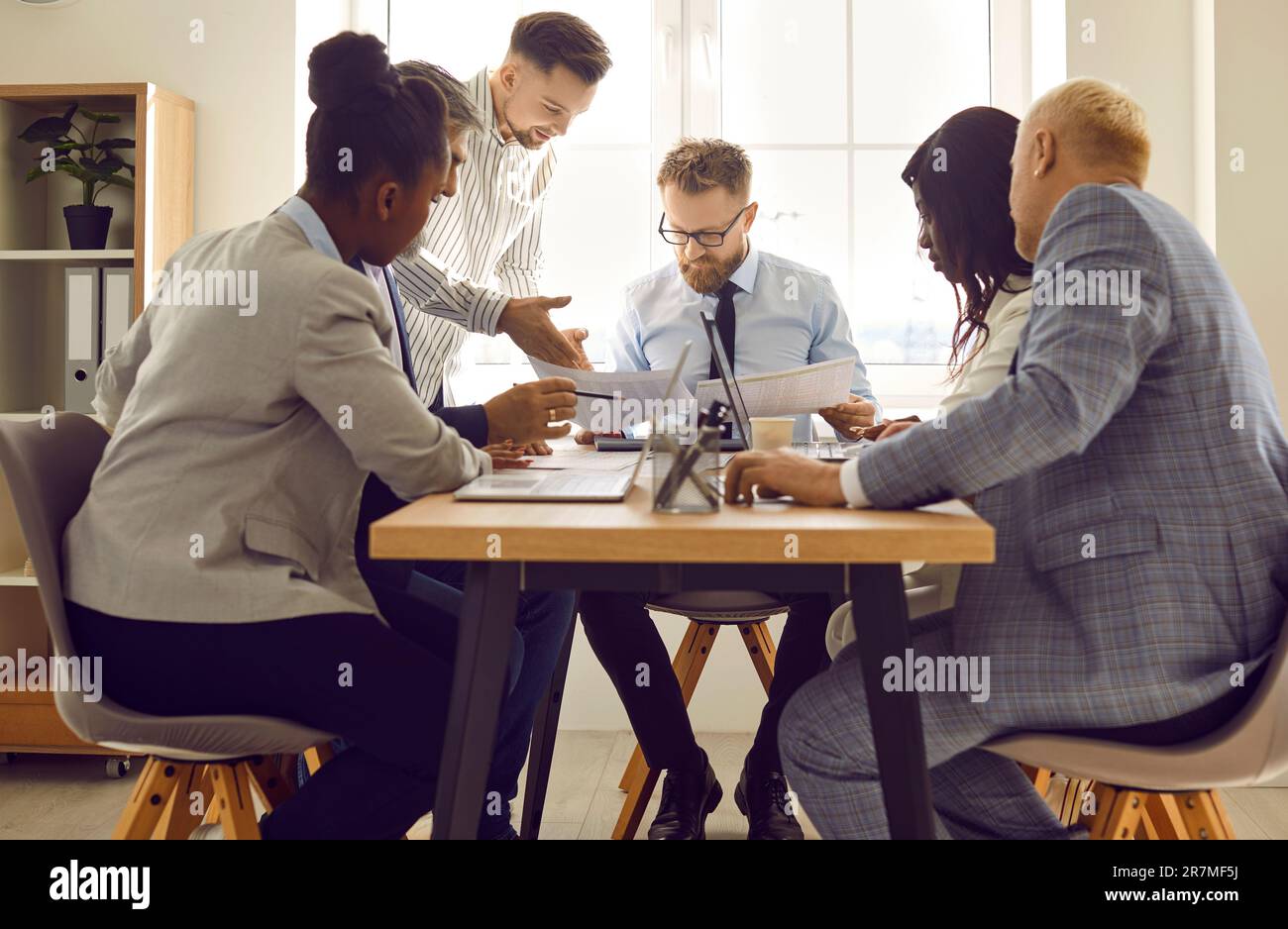 Group of business people working and communicating while sitting at ...