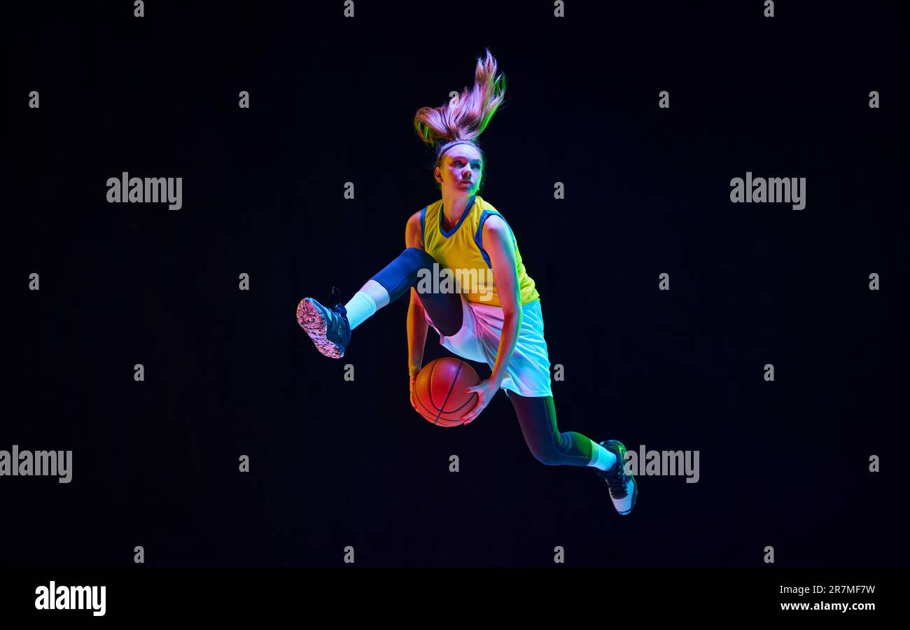 Dynamic image of motivated sportsman, young girl playing basketball ...