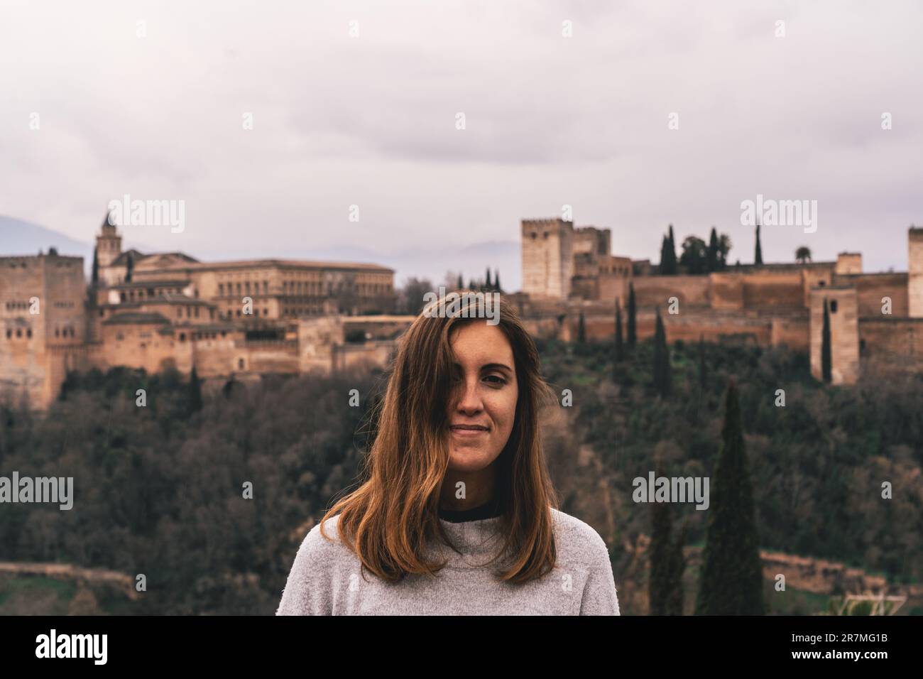 A person poses, framed by the Alhambra's grandeur, capturing a moment ...