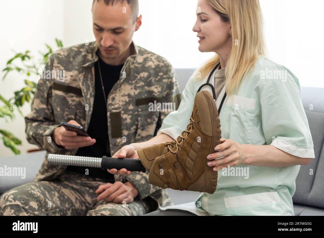 A female prosthetist wraps a plaster cast around the leg stump ...