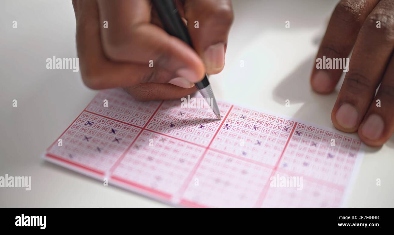 Person's Hand Marking Number On Lottery Ticket With Pen Stock Photo - Alamy