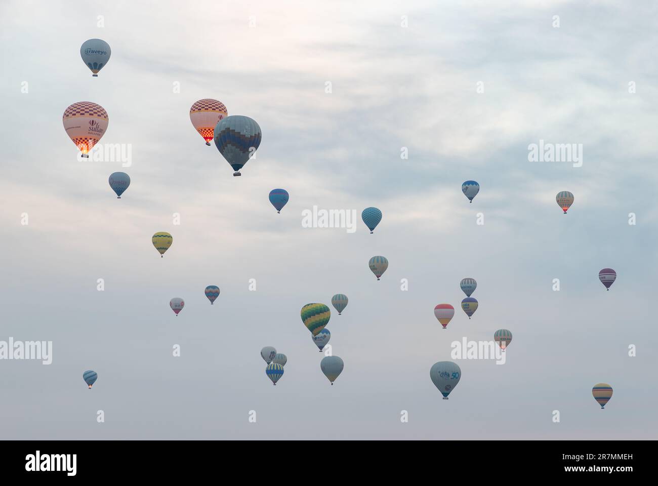 A picture of multiple hot air balloons flying on a cloudy sky in ...