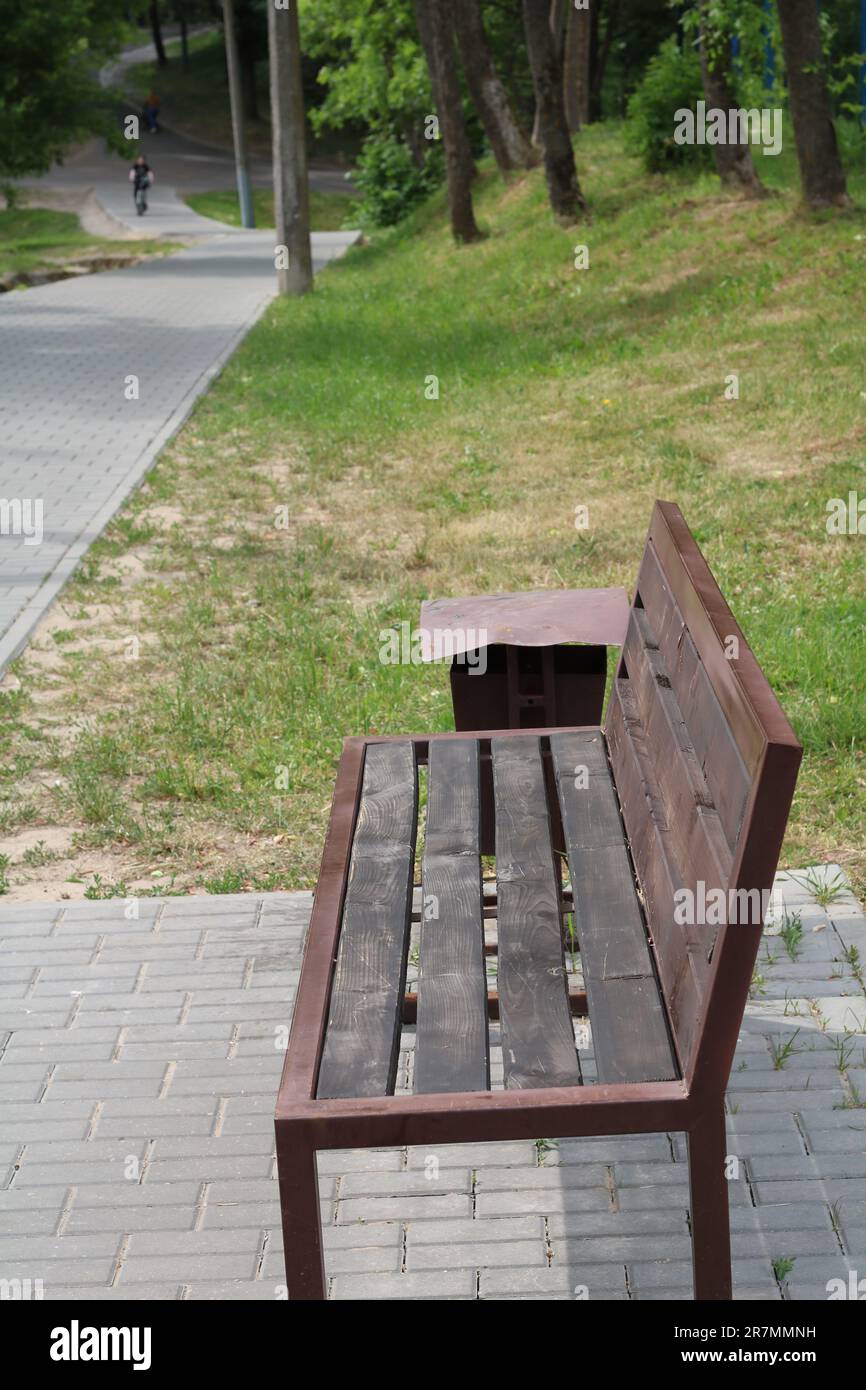photo of the bench standing near the walkway in the park Stock Photo ...