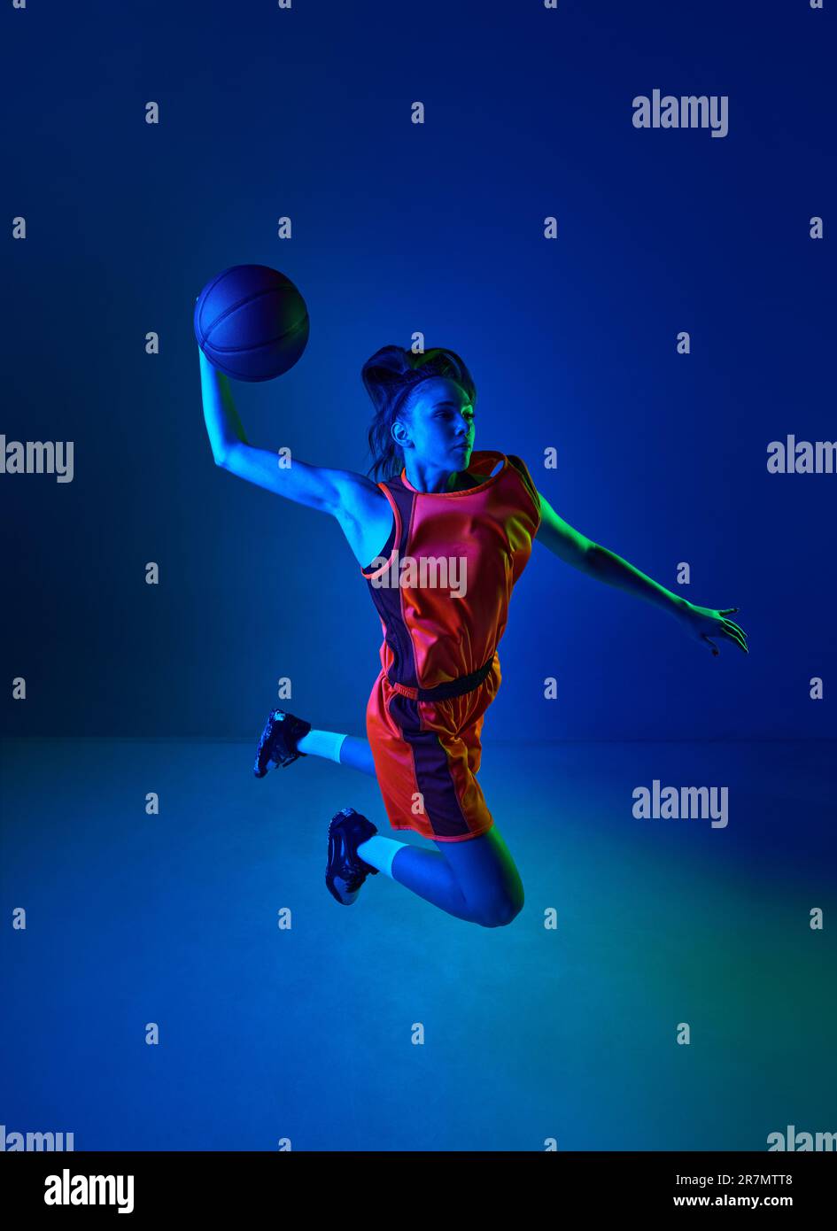 Slam dunk. Top view of young girl, basketball player throwing ball ...