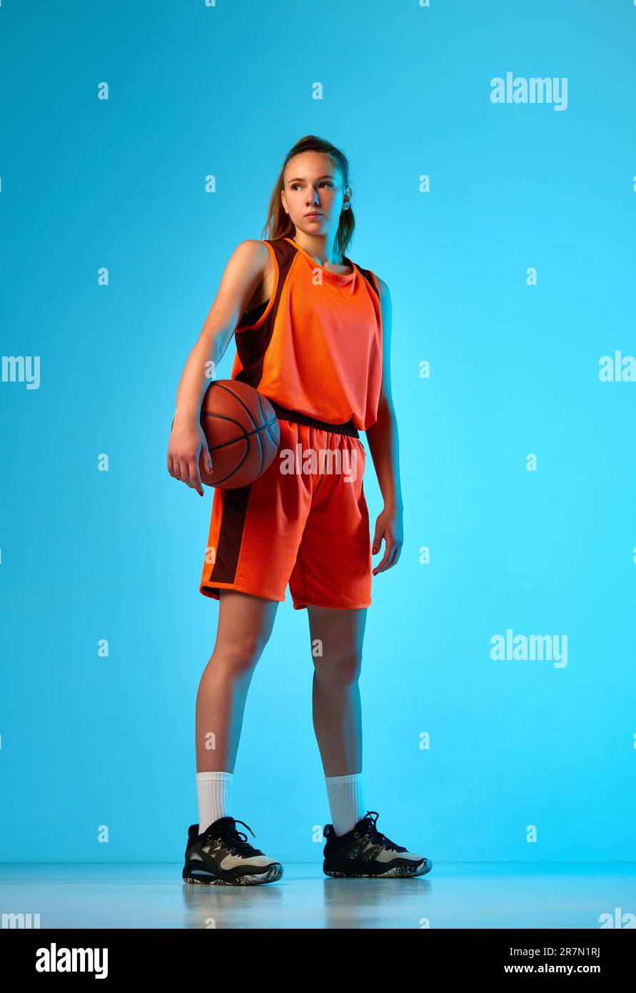 Full-length portrait of young girl, basketball player in uniform posing ...
