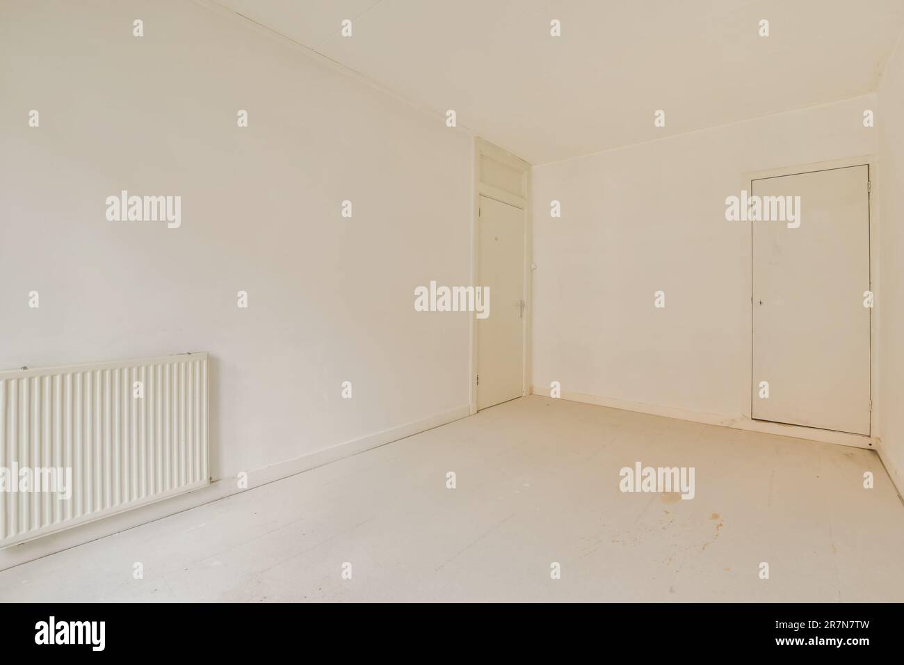 an empty room with white walls and flooring, there is a rad door on the ...