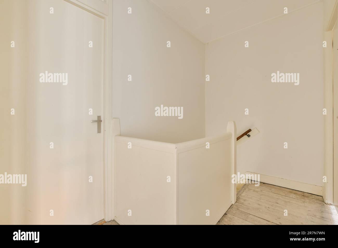 an empty room with white walls and wood flooring the door is open on ...