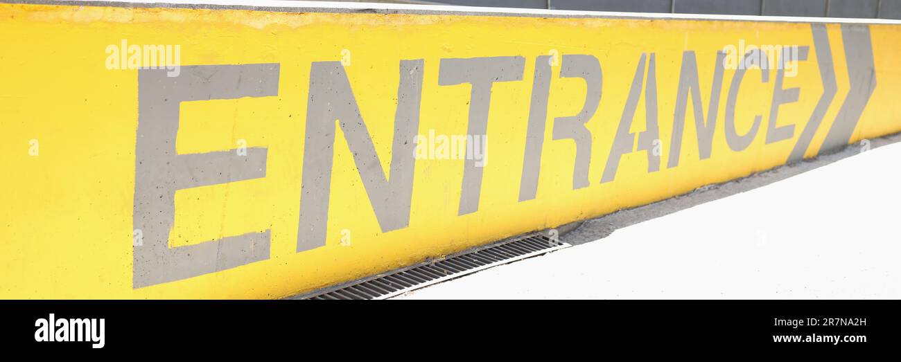 Closeup of arrow sign and inscription entrance on wall Stock Photo - Alamy