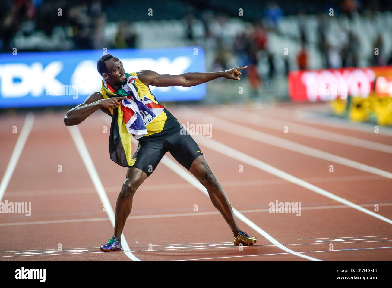 Usain Bolt on the day of his farewell, saluting and with the flag of ...