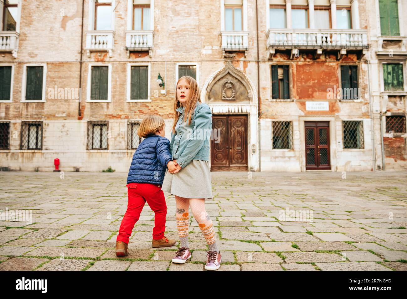 Outdoor portrait of cute little boy and girl, stylish kids playing ...