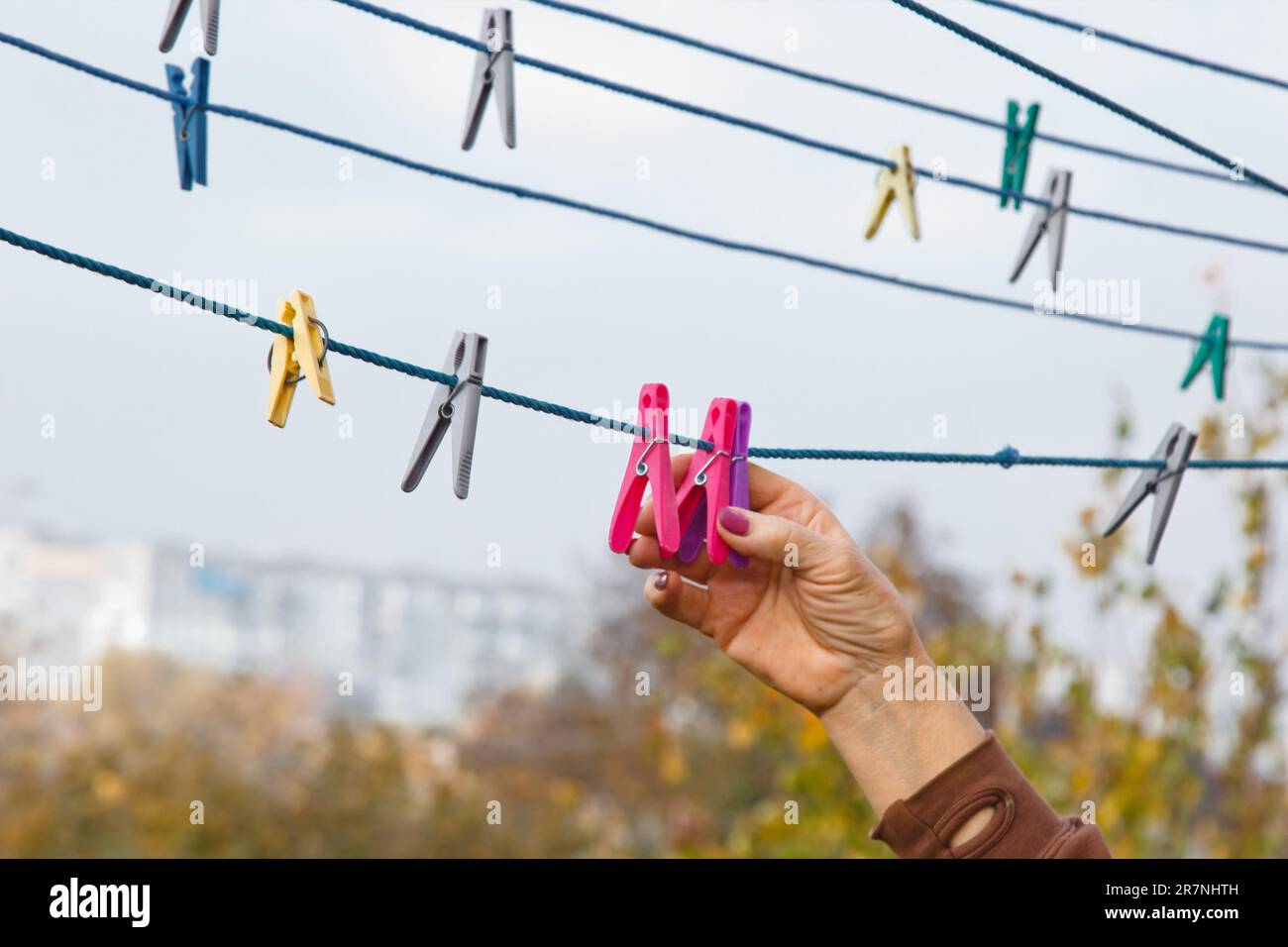 Laundry woman hangs clean wet cloth on clothes dryer after washing at ...